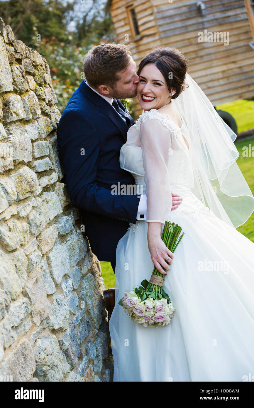 A bride and groom on their wedding day, laughing and embracing Stock ...