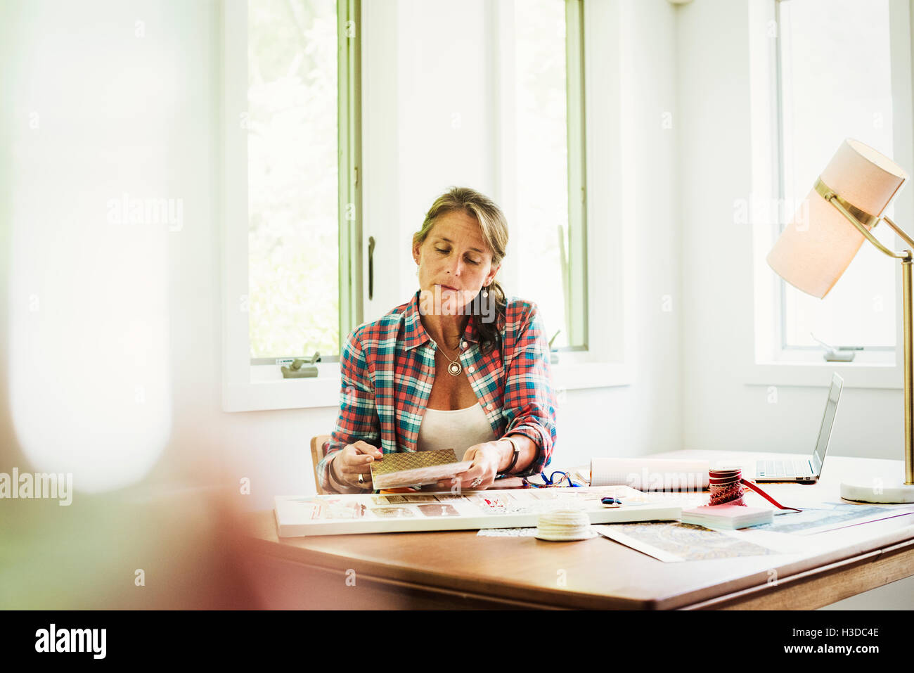 A woman creating a collage picture with material and paper Stock Photo ...