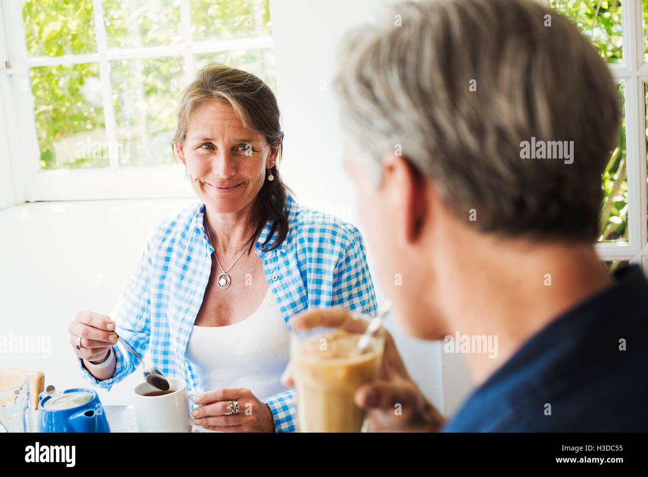 A woman and making talking over a cup of tea Stock Photo - Alamy