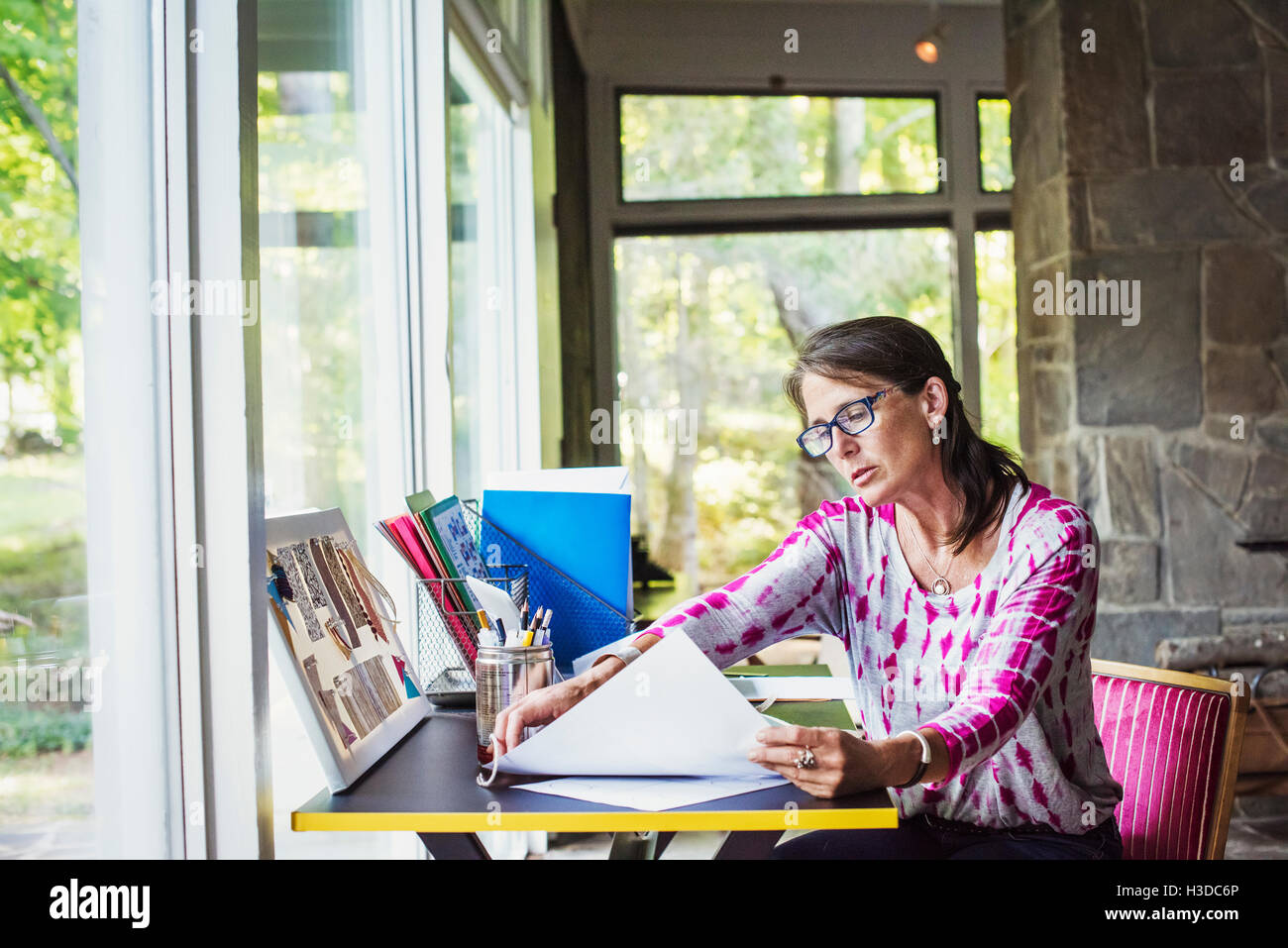 Woman sitting at a desk at home, working Stock Photo - Alamy
