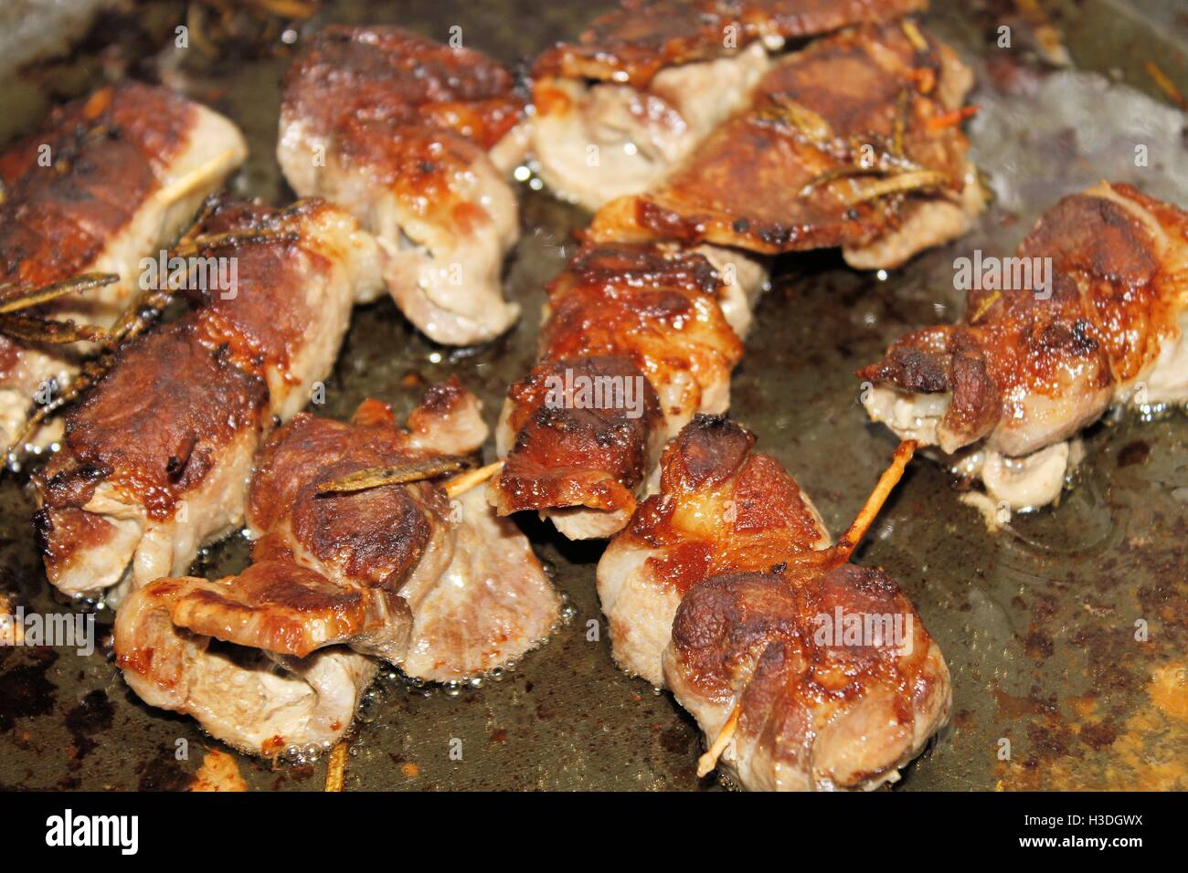 small pieces of meat wrapped cooked in a pan Stock Photo - Alamy