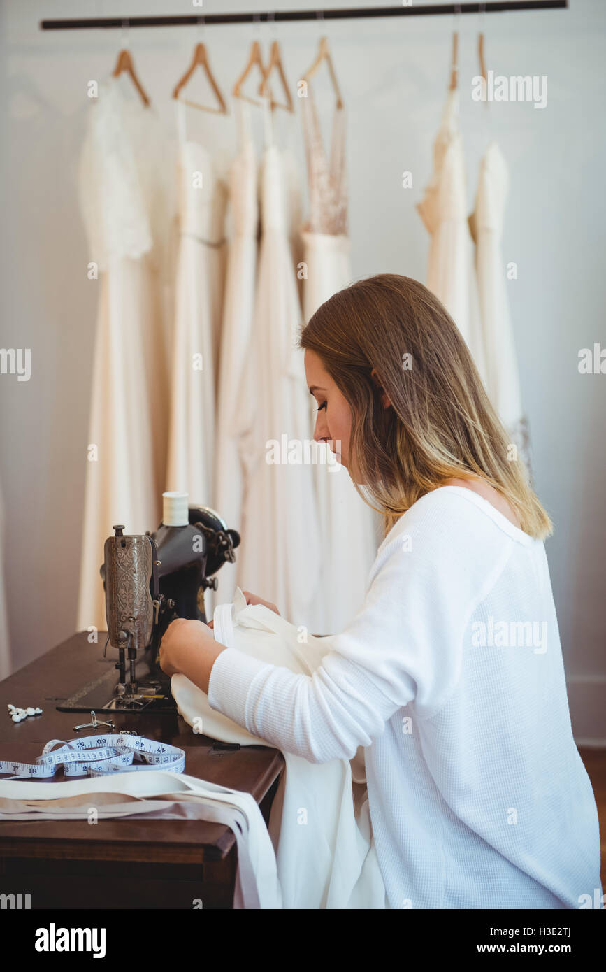 Female dressmaker sewing in the studio Stock Photo - Alamy