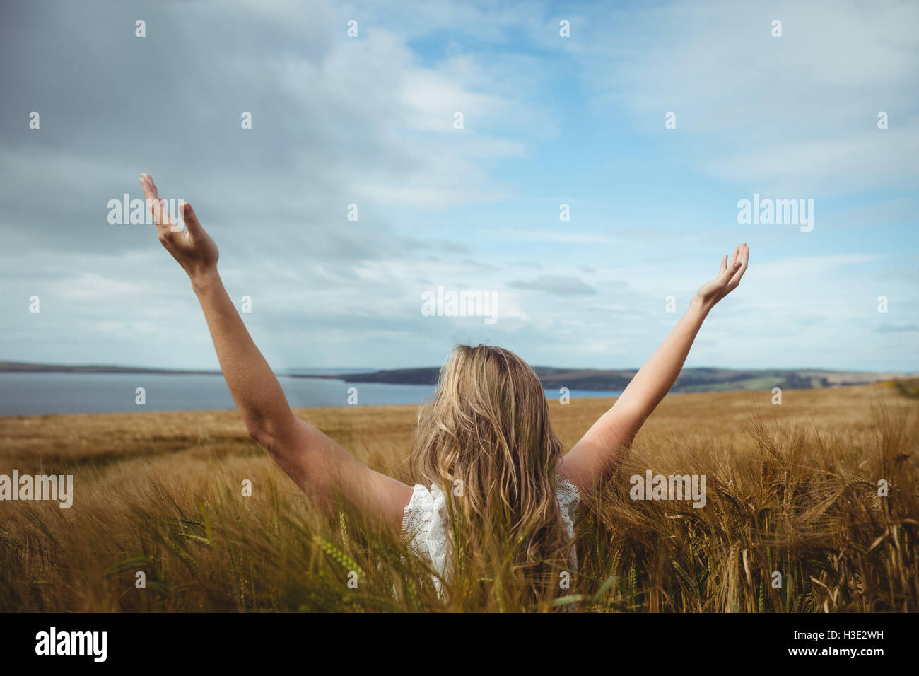 Rear view woman standing with arms outstretched Stock Photo - Alamy