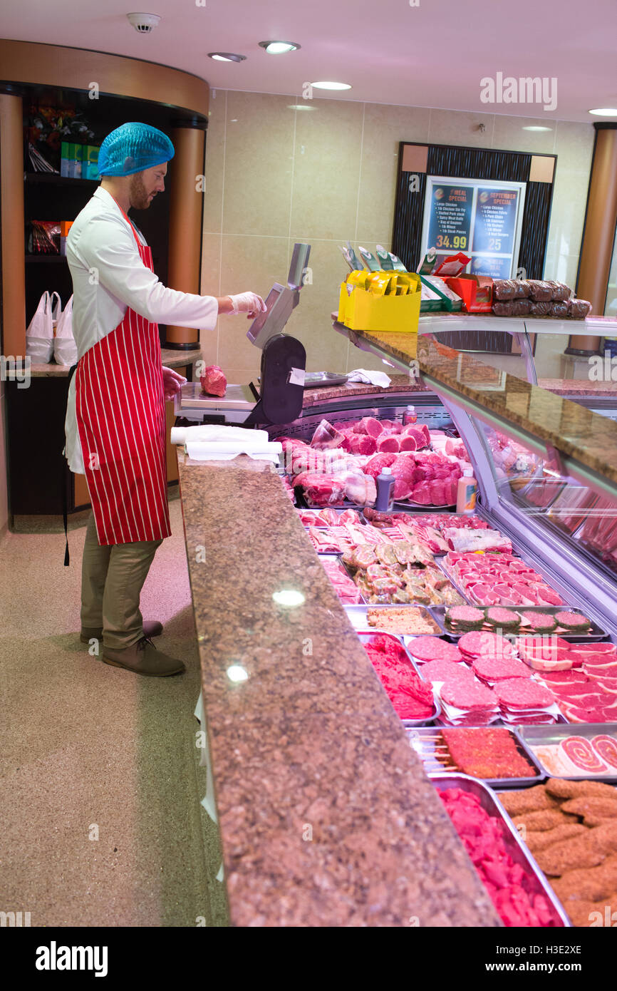 Butcher checking the weight of meat at counter Stock Photo - Alamy