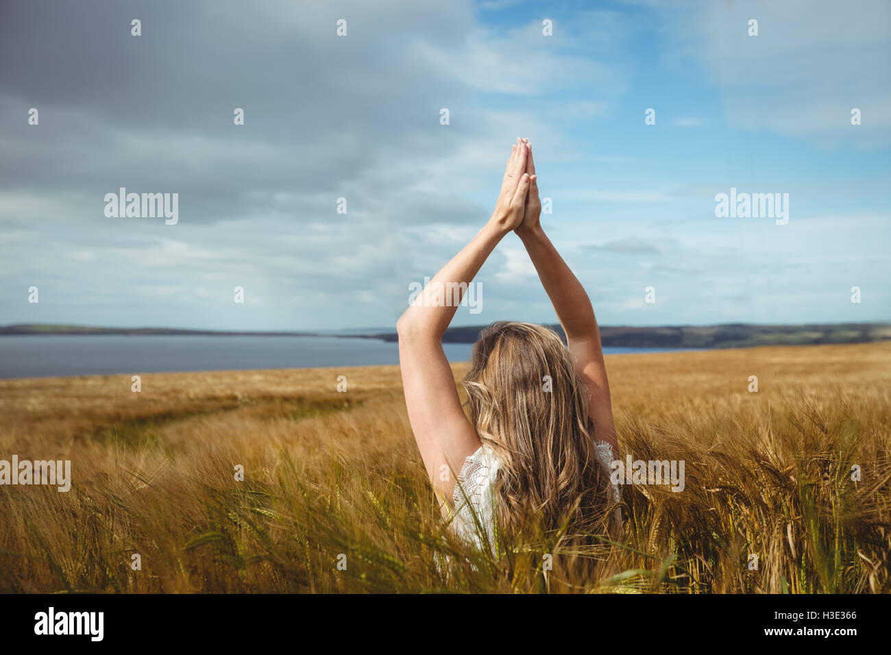 Woman with hands raised over head in prayer position in field Stock ...