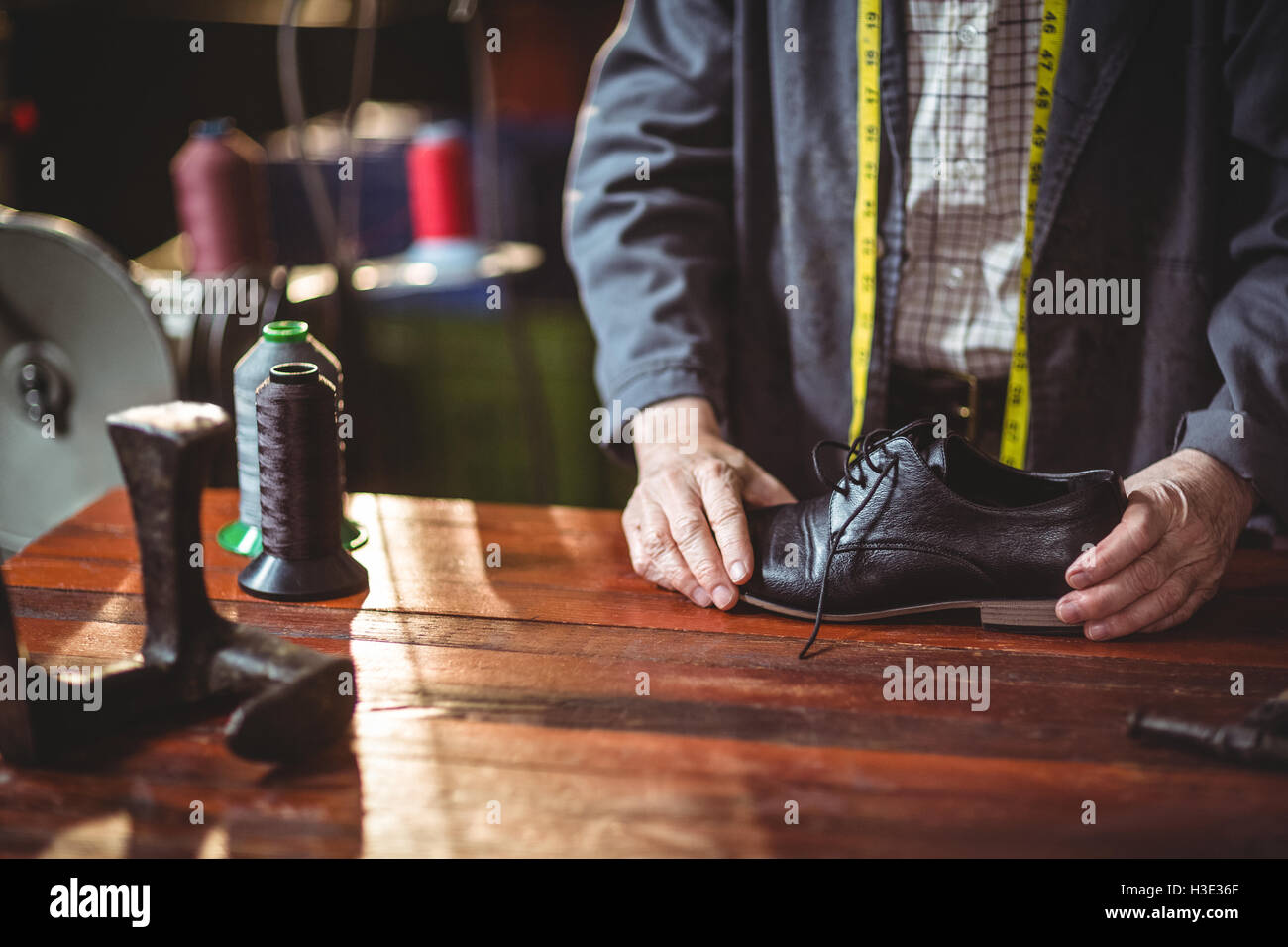 Shoemaker examining a shoe Stock Photo - Alamy