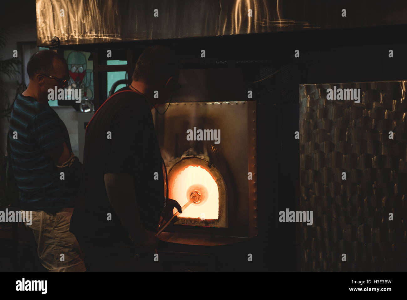 Team of glassblowers heating a glass in furnace Stock Photo - Alamy