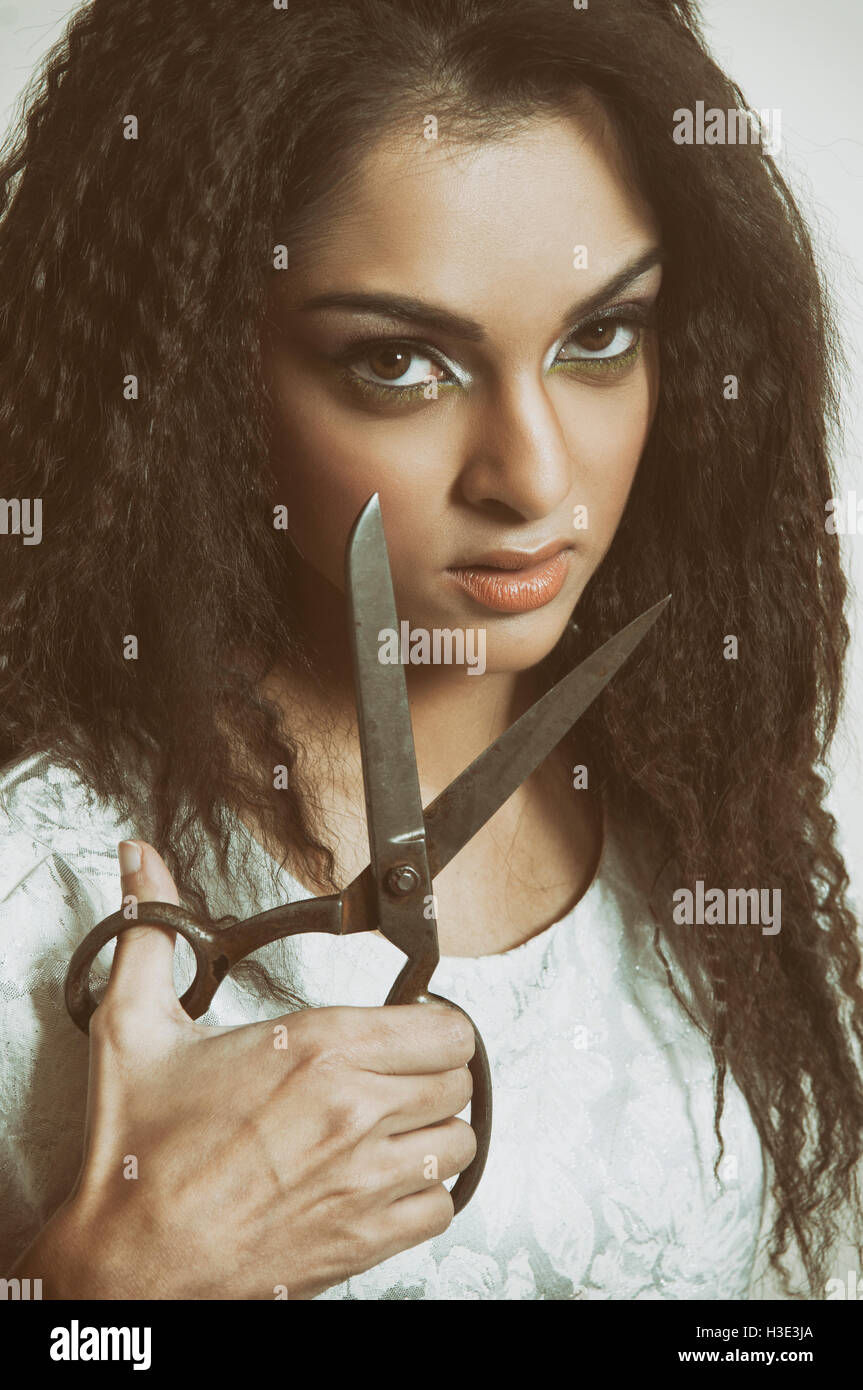 Angry woman holding a pair of scissors Stock Photo - Alamy