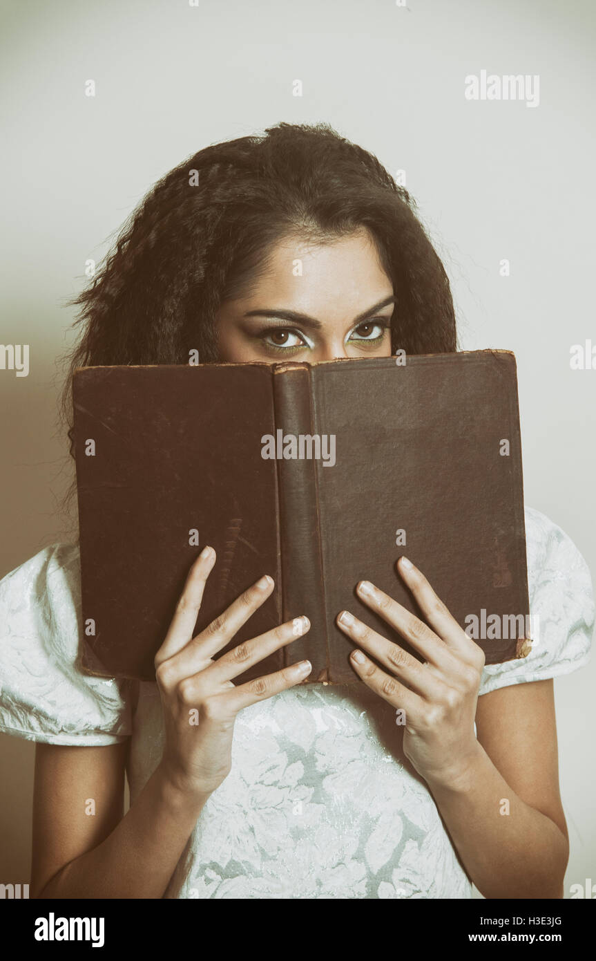 Young woman hiding face with an open book Stock Photo - Alamy