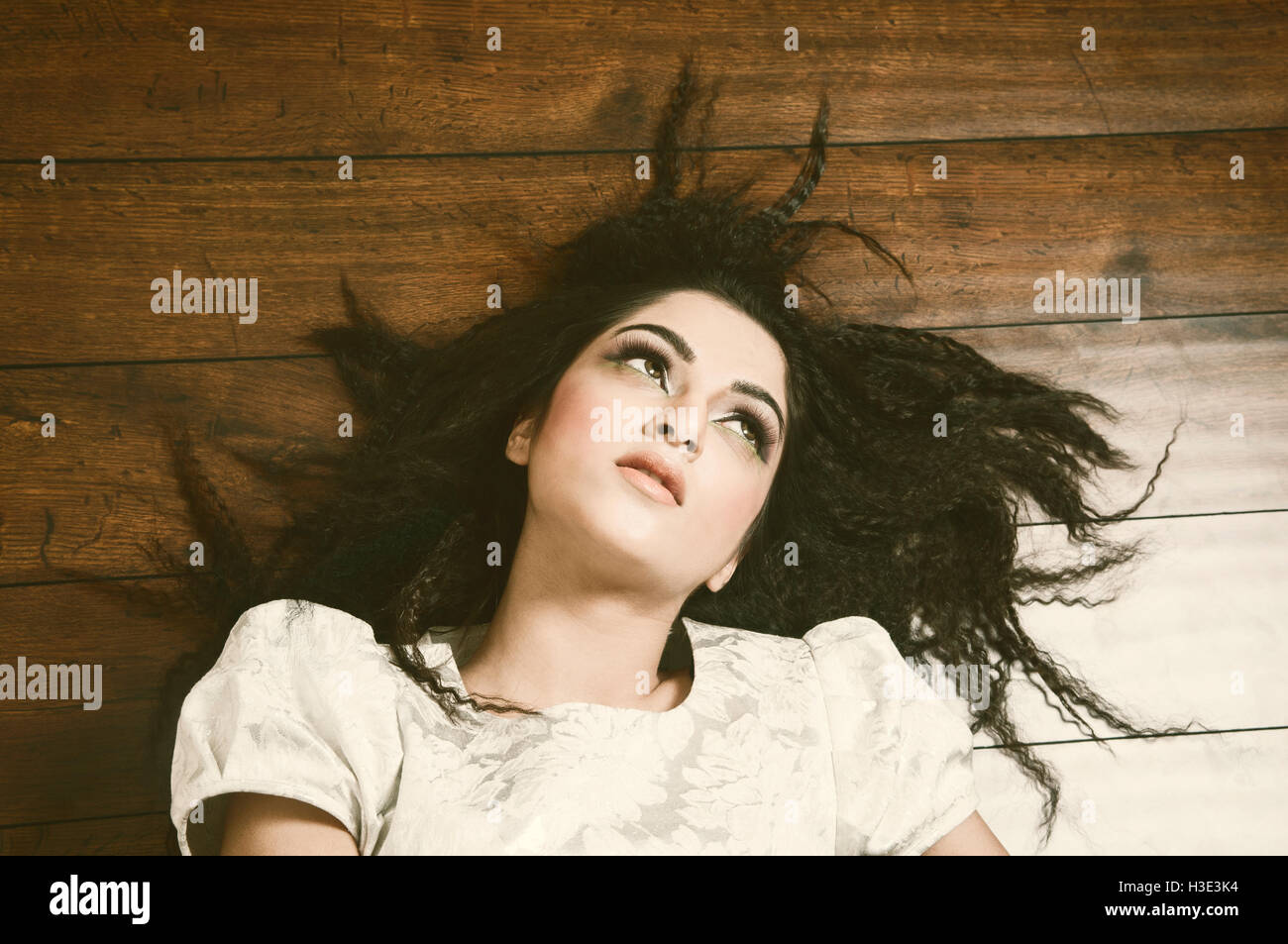 Young woman laying down on the floor looking up Stock Photo - Alamy