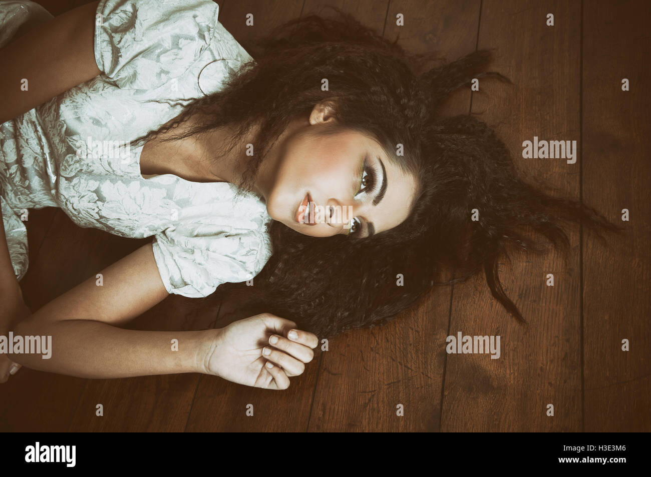 Young woman laying down on the floor looking up Stock Photo - Alamy