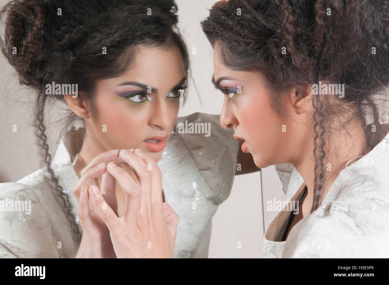 Angry woman looking into the mirror Stock Photo - Alamy
