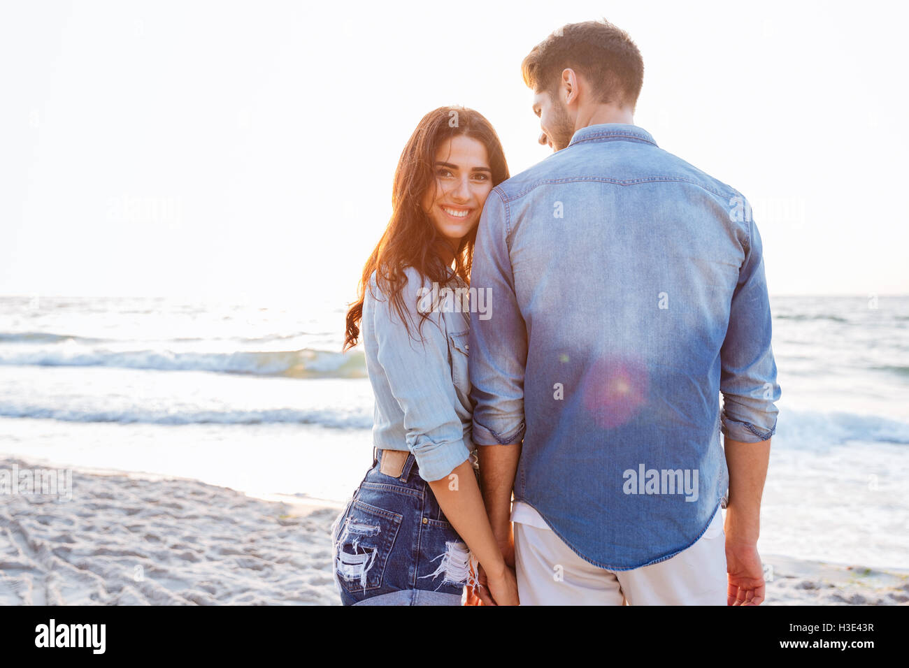 Beautiful young woman holding her boyfriend hand who standing backwards ...