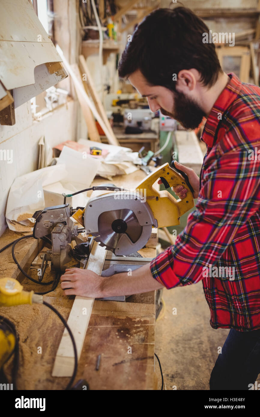 Man cutting wooden plank with electric saw Stock Photo - Alamy