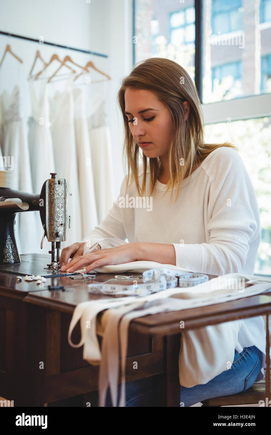 Female dressmaker sewing in the studio Stock Photo - Alamy