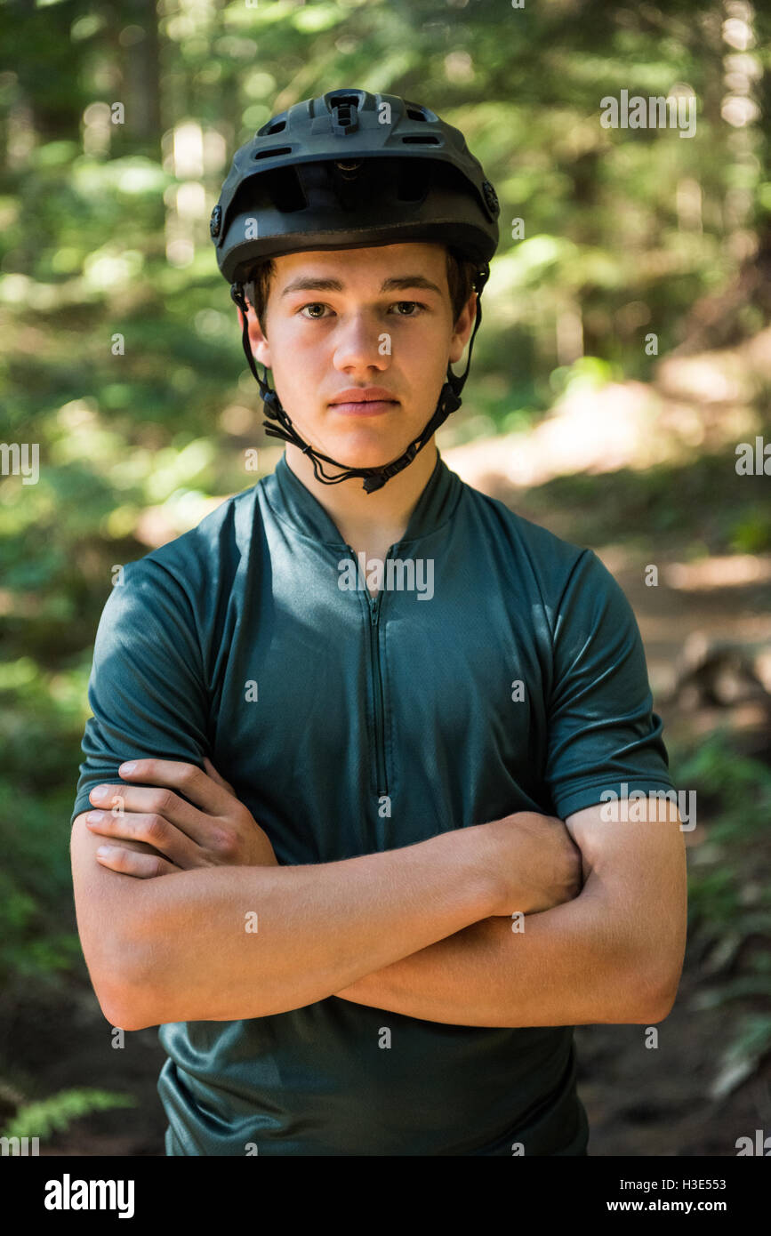 Male cyclist standing with arms crossed in forest Stock Photo - Alamy