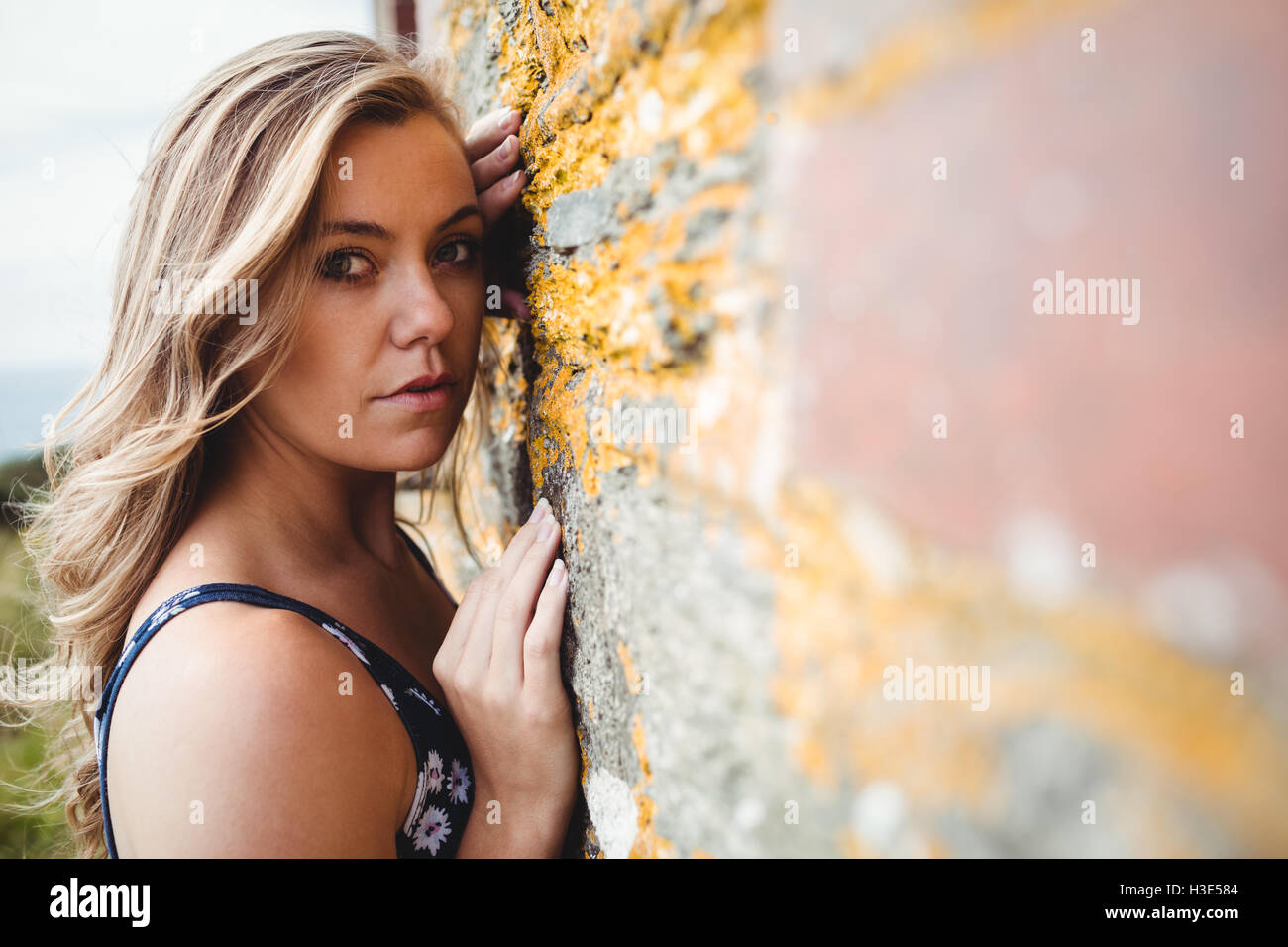 Portrait of woman leaning on wall Stock Photo - Alamy