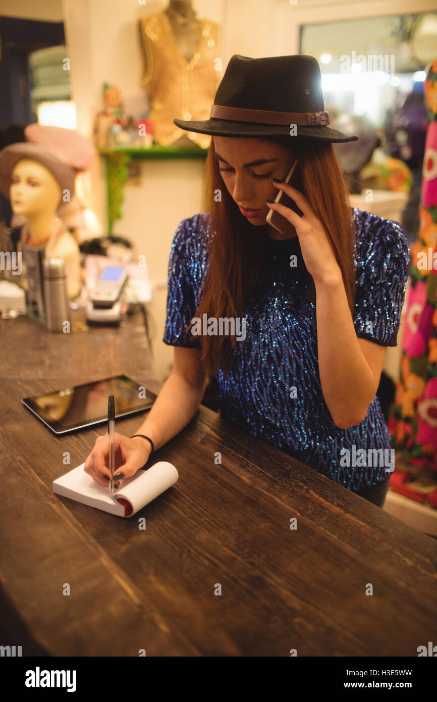 Female staff taking order on mobile phone Stock Photo - Alamy