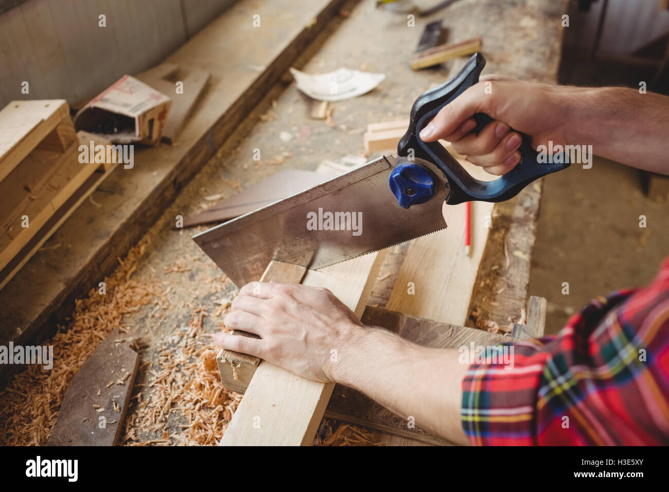 Man cutting a wooden plank Stock Photo - Alamy