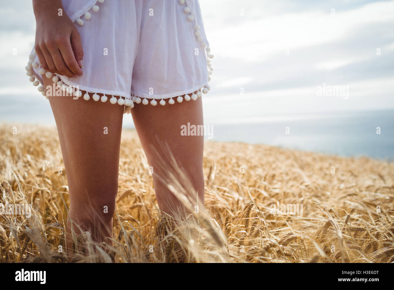 Mid section of woman standing in wheat field Stock Photo - Alamy