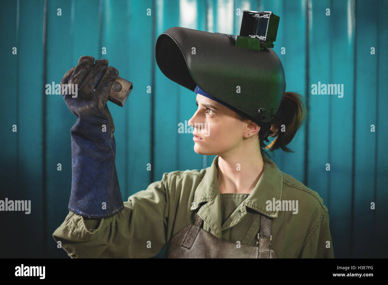 Female welder examining a piece of metal Stock Photo - Alamy