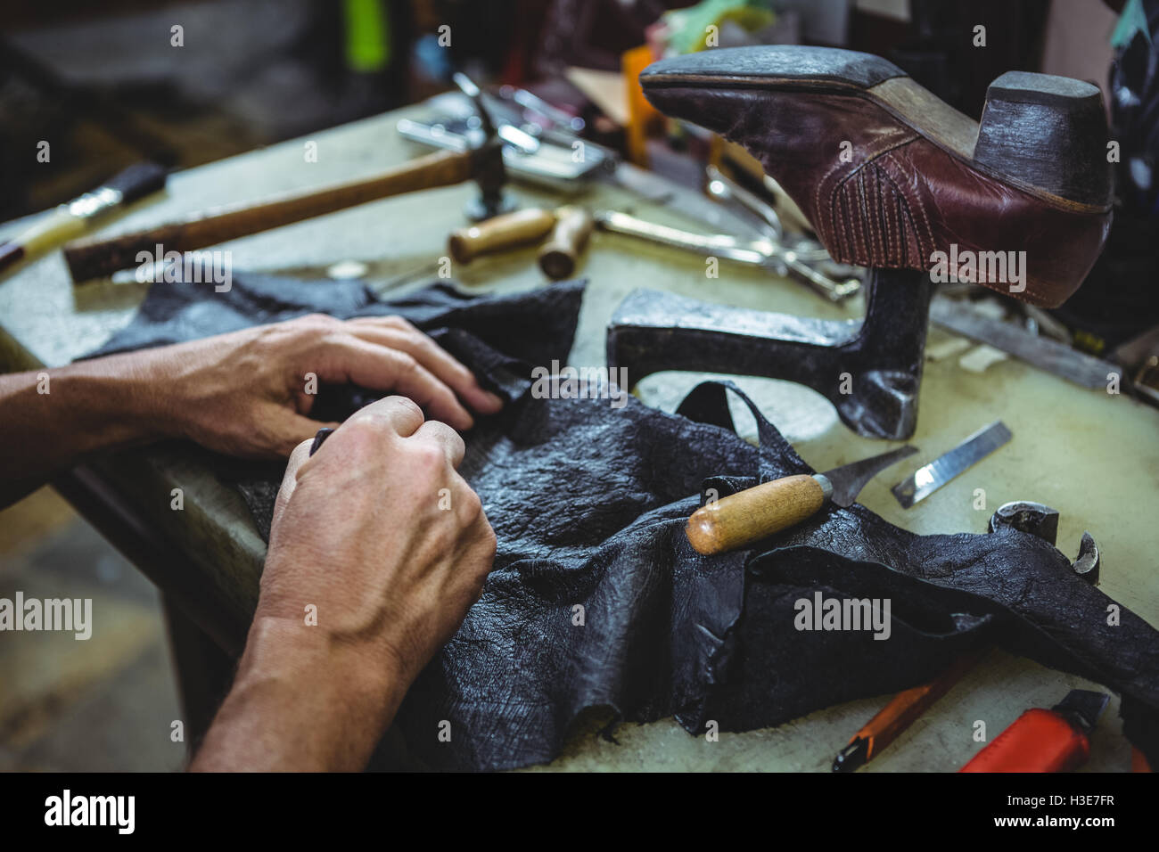 Shoemaker cutting a piece of material Stock Photo - Alamy
