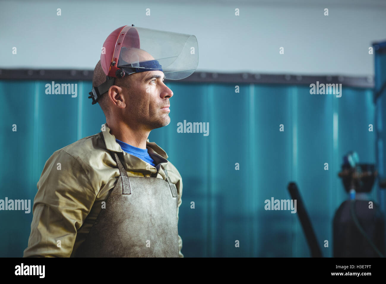 Male welder standing and looking away Stock Photo - Alamy