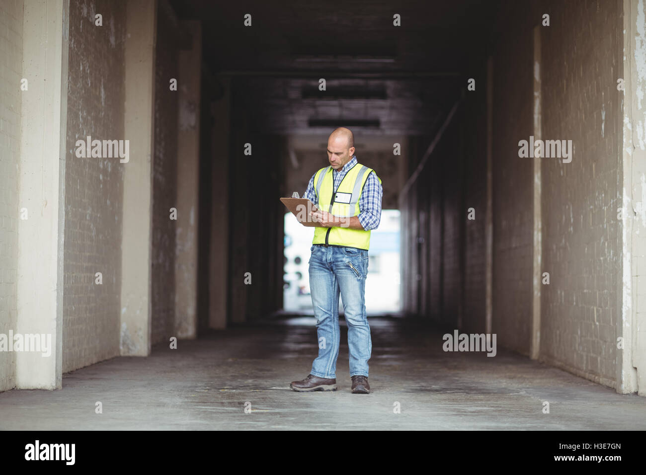 Construction worker writing on a clipboard Stock Photo - Alamy