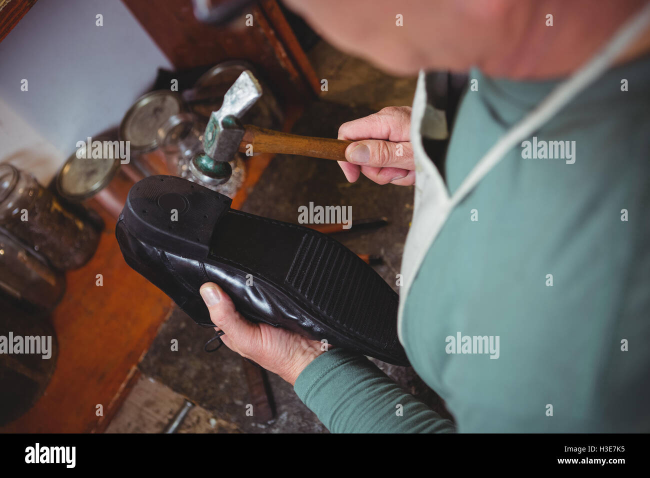 Shoemaker hammering on a shoe Stock Photo - Alamy