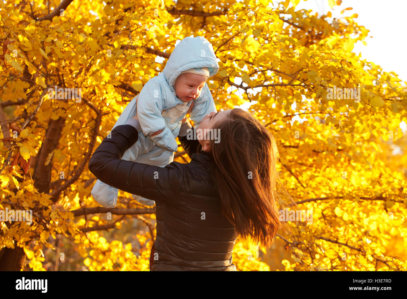 Happy mother hugging her baby to the sun, walk in the park Stock Photo ...