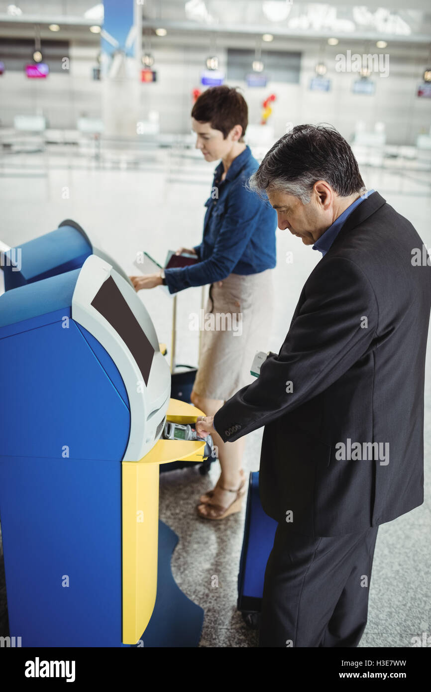 Business people using self service check-in machine Stock Photo - Alamy