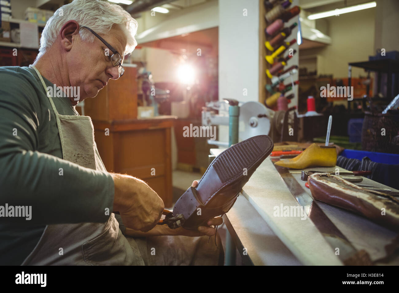 Shoemaker repairing a shoe Stock Photo - Alamy