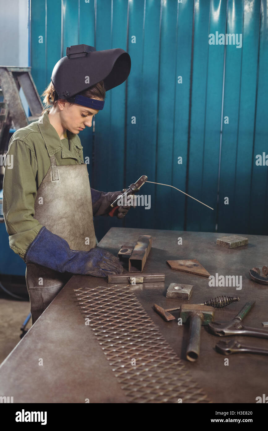 Female welder holding welding arch Stock Photo - Alamy