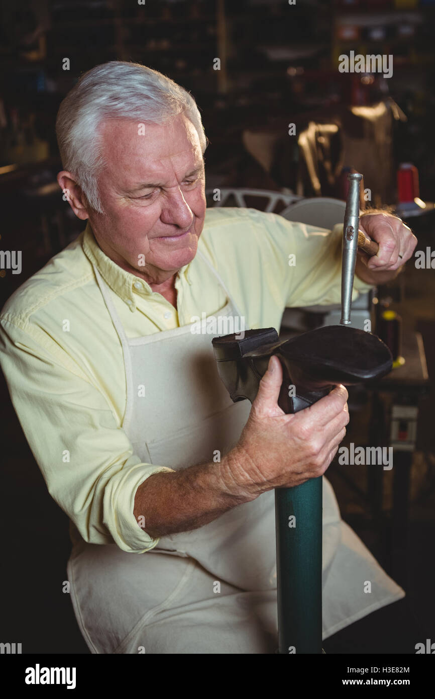 Shoemaker making a shoe with hammer Stock Photo - Alamy