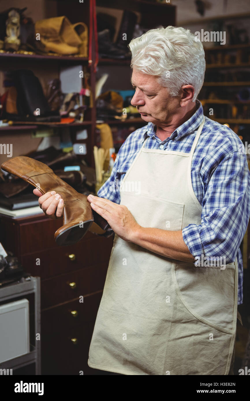 Shoemaker examining a shoe Stock Photo - Alamy