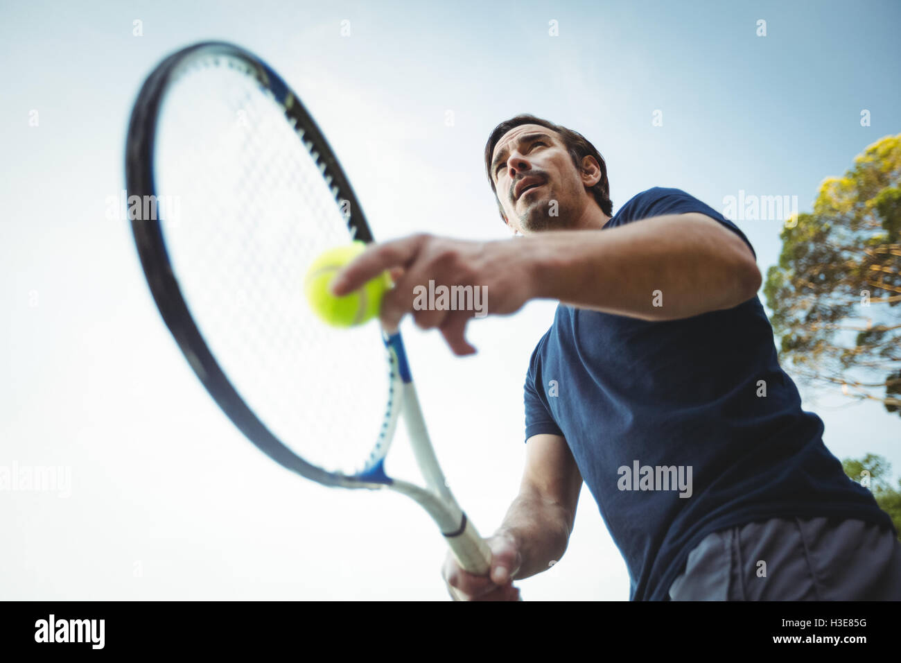 Man with tennis racket ready to serve Stock Photo - Alamy