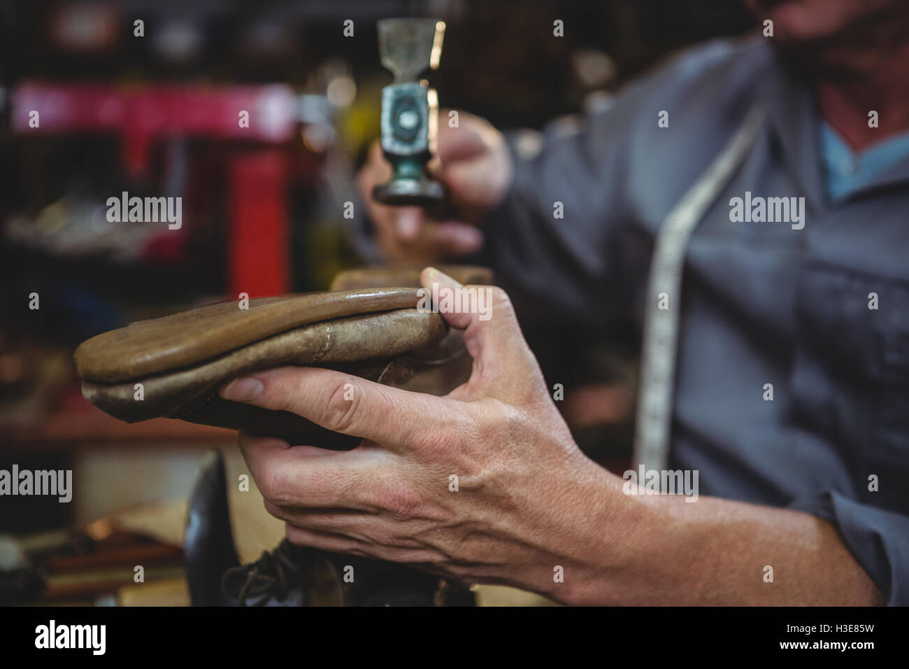 Shoemaker hammering on a shoe Stock Photo - Alamy