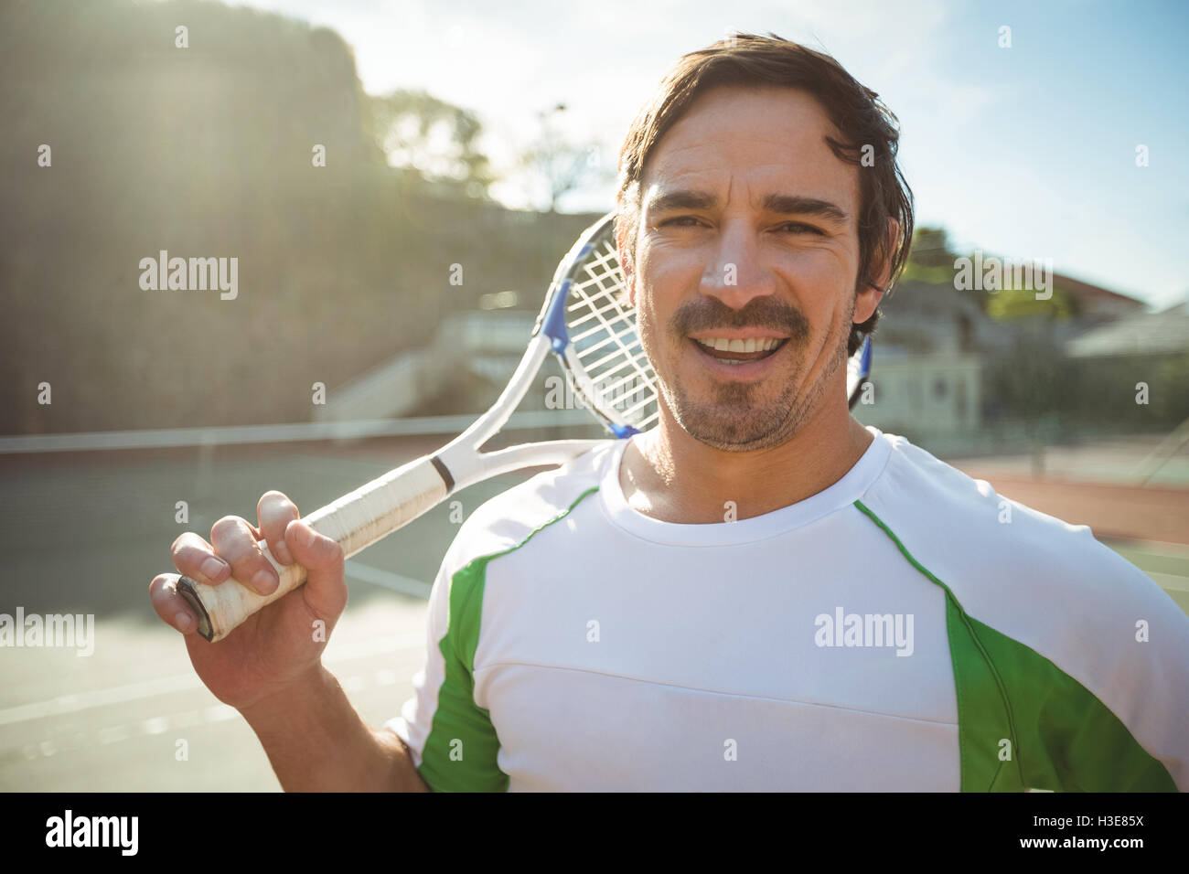 Portrait of happy man standing with a tennis racket Stock Photo - Alamy
