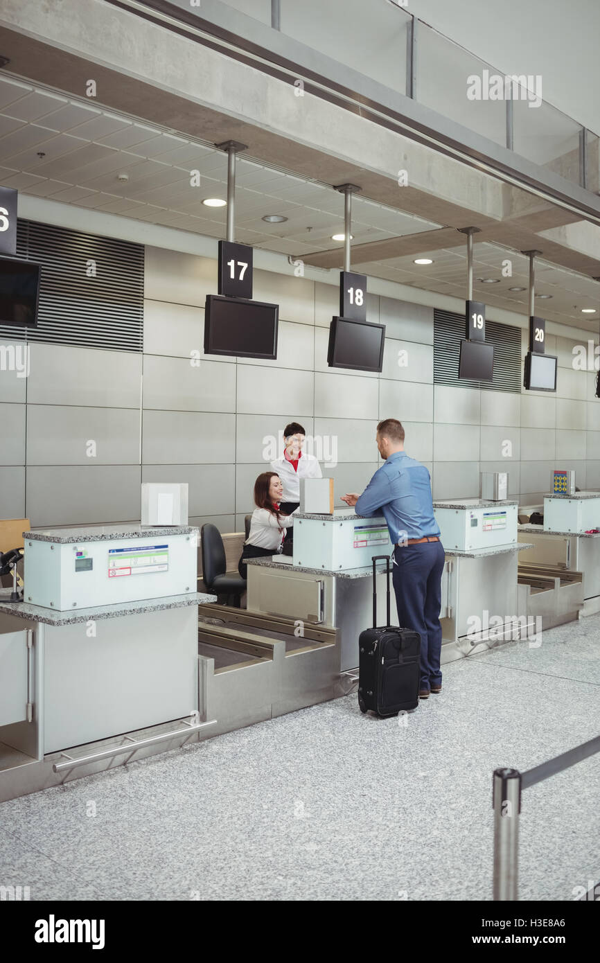 Airline check-in attendant handing passport to passenger Stock Photo ...