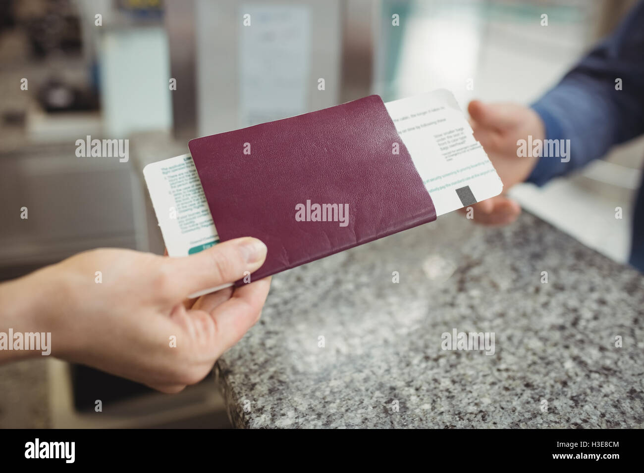 Airline check-in attendant handing passport to passenger Stock Photo ...