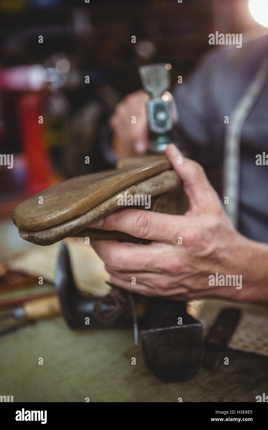 Shoemaker hammering on a shoe Stock Photo - Alamy