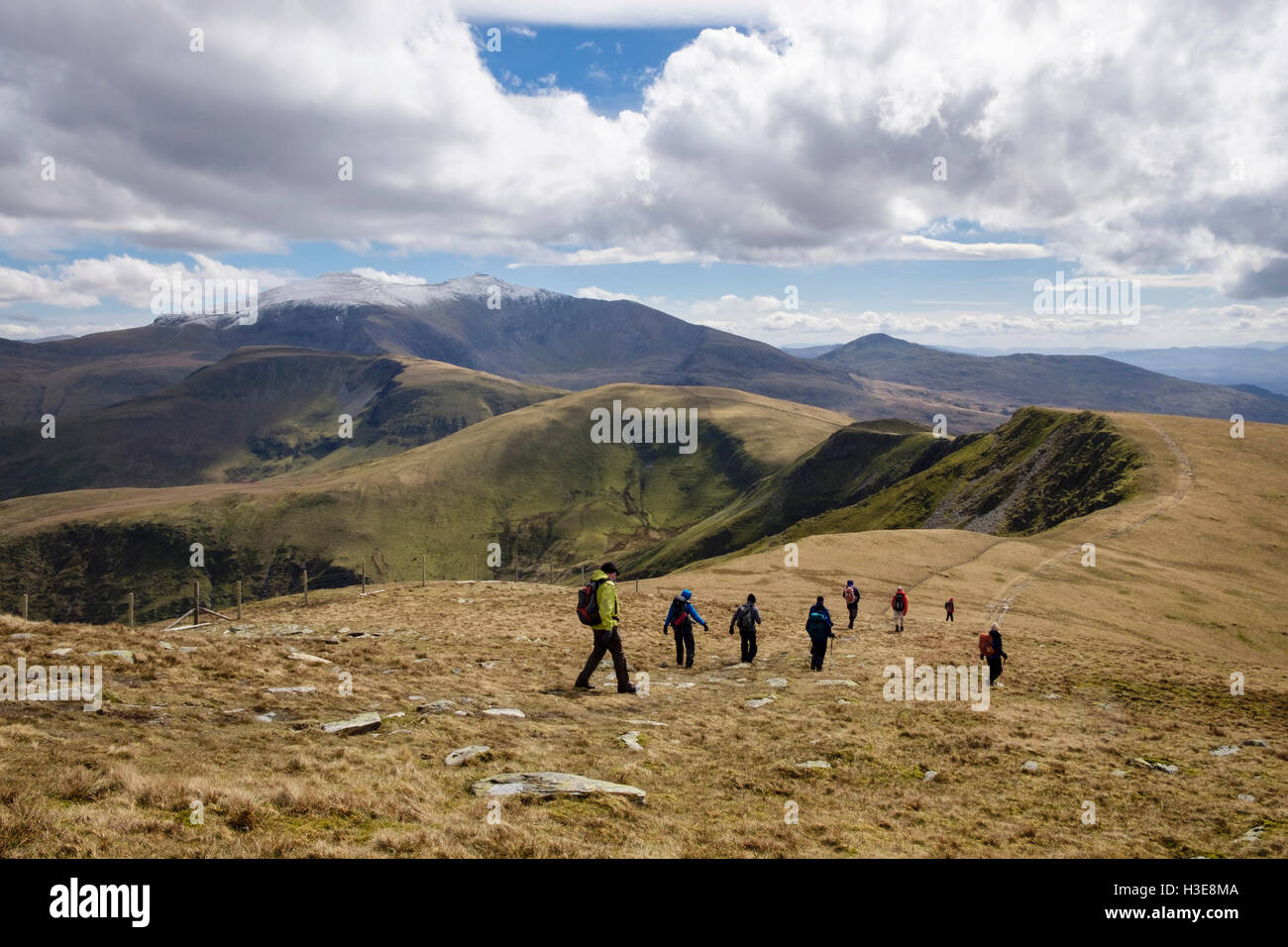 Hikers hiking down Moel Eilio with distant view of Mount Snowdon range ...