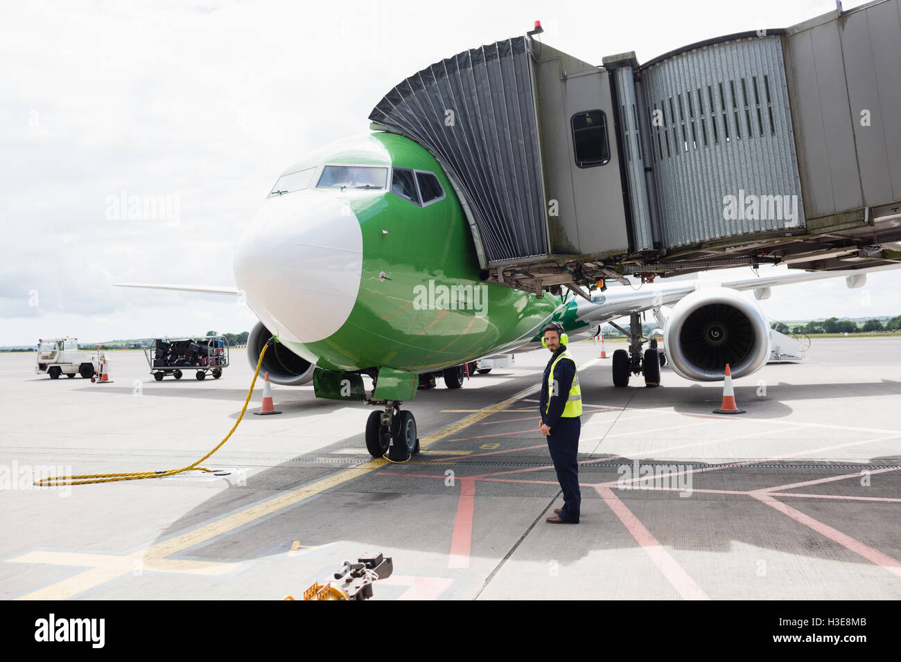 Airport ground crew worker standing next to airplane Stock Photo - Alamy