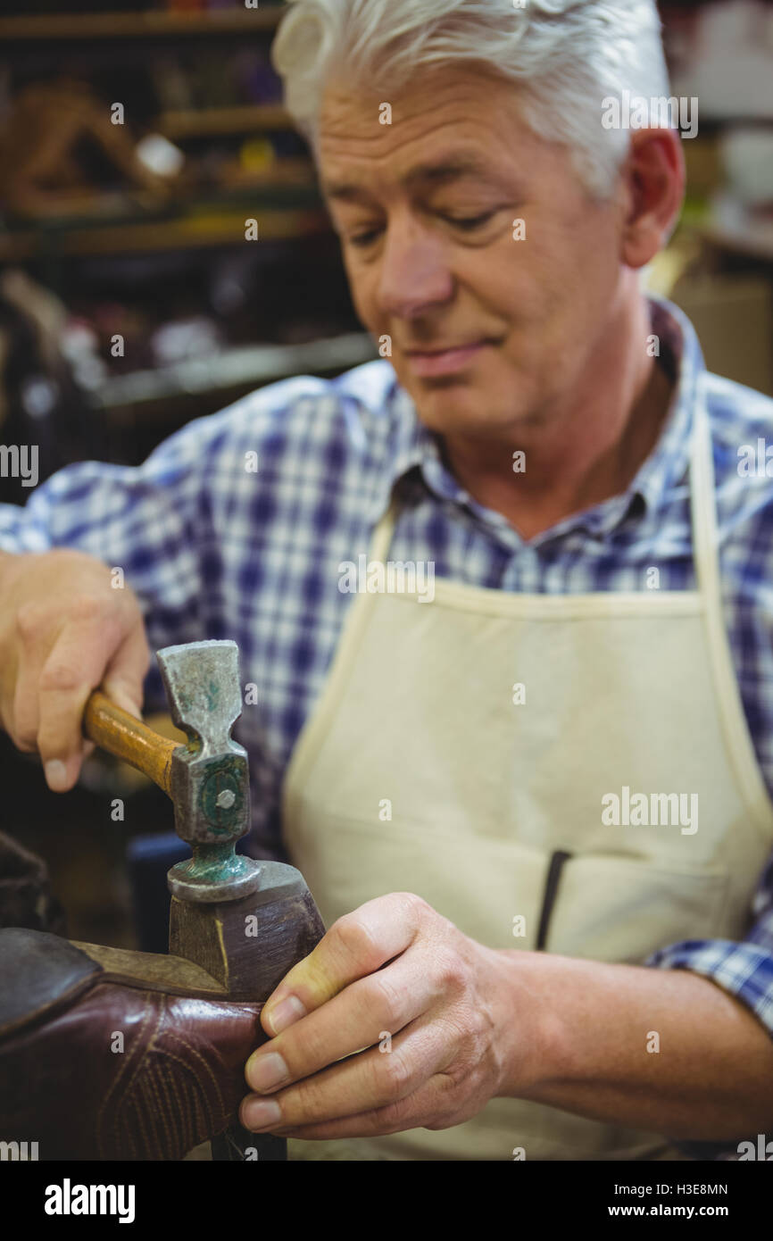 Shoemaker hammering on a shoe Stock Photo - Alamy