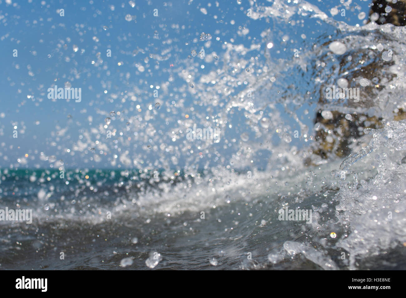 Sea wave splashing over the shore rocks with a high sea spray Stock ...