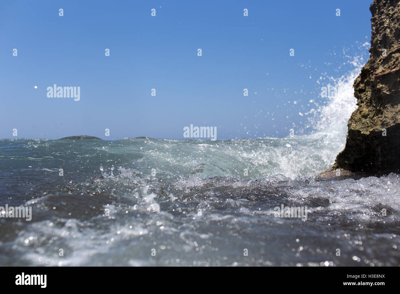 Sea wave splashing over the shore rocks with a high sea spray Stock ...