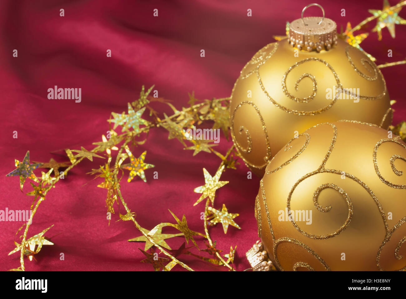 Two golden Christmas bulbs with gold chain on a red background Stock ...