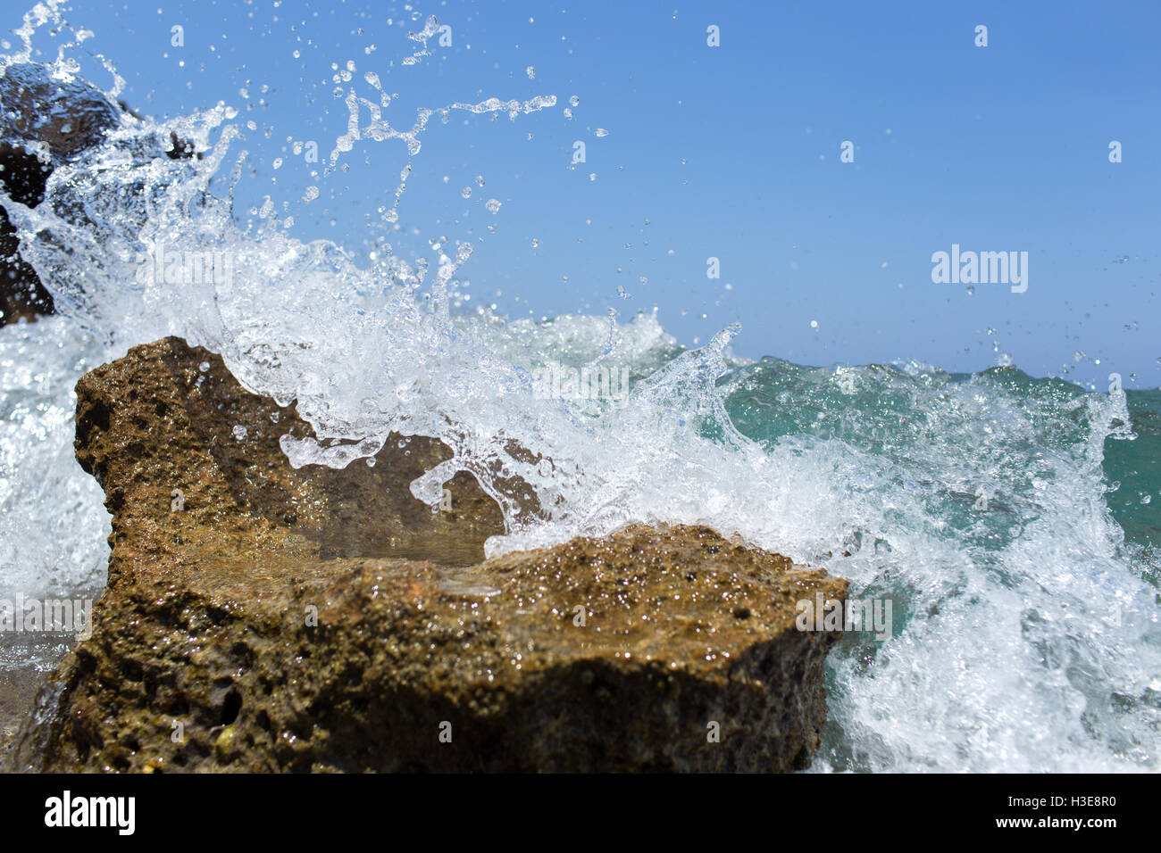 Sea wave splashing over the shore rocks with a high sea spray Stock ...