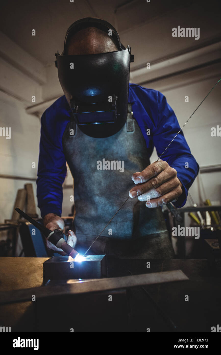 Male welder working on a piece of metal Stock Photo - Alamy
