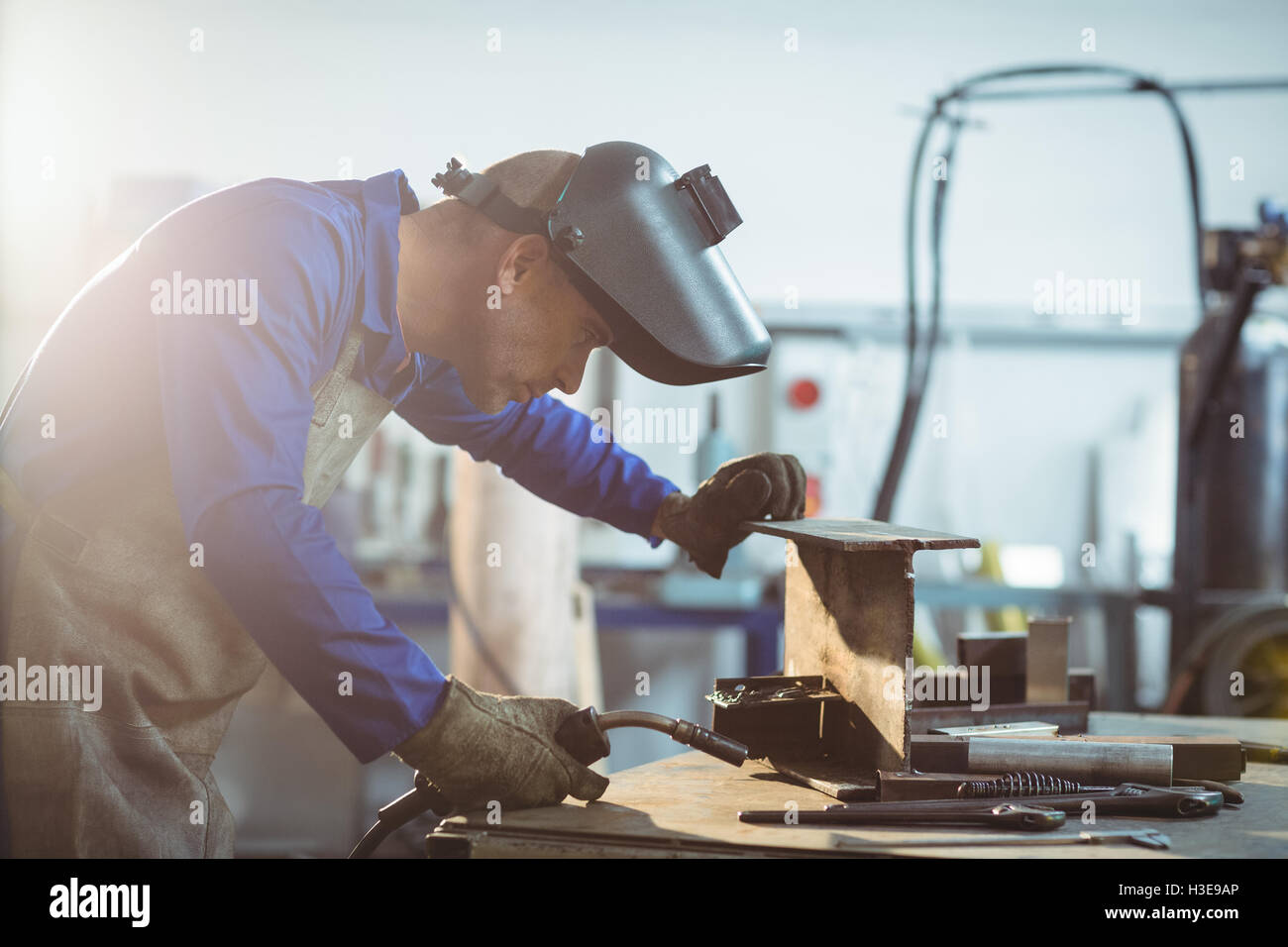 Male welder examining a piece of metal Stock Photo - Alamy